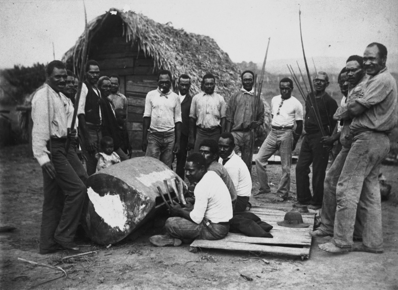 South Sea Islander labourers gathered around a drum outside a hut in ...